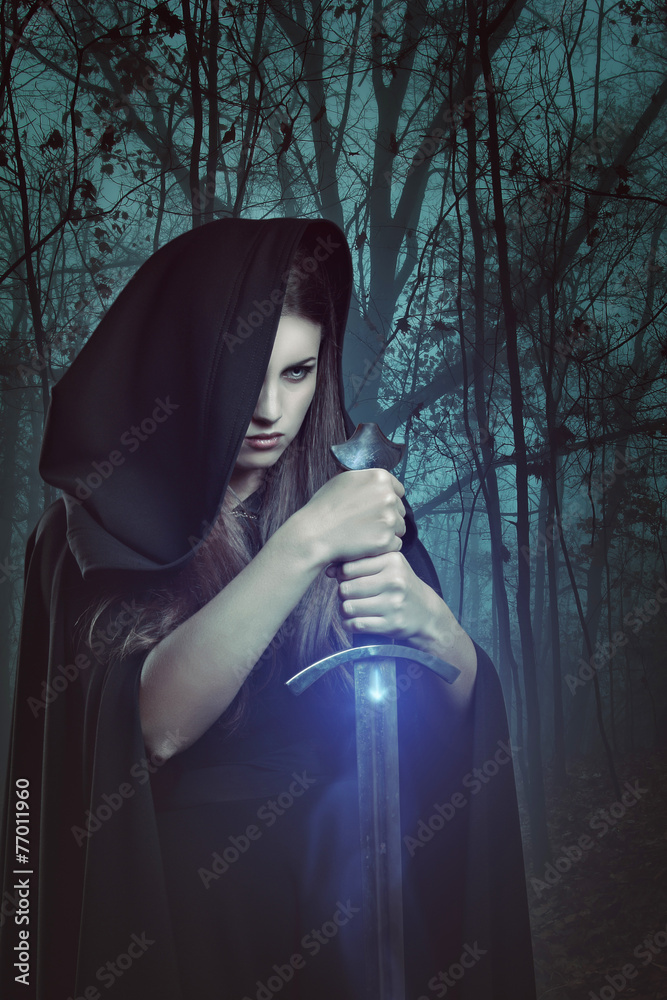 Beautiful woman with magic sword in a dark forest Stock-Foto | Adobe Stock