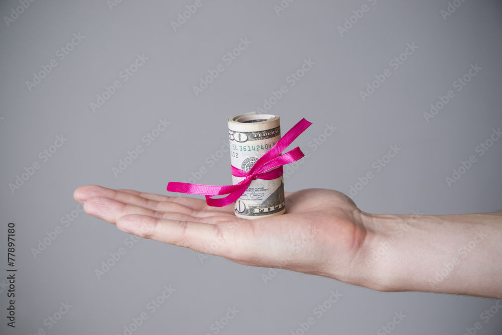Money with bow in male hand on a gray background Stock 사진 | Adobe Stock