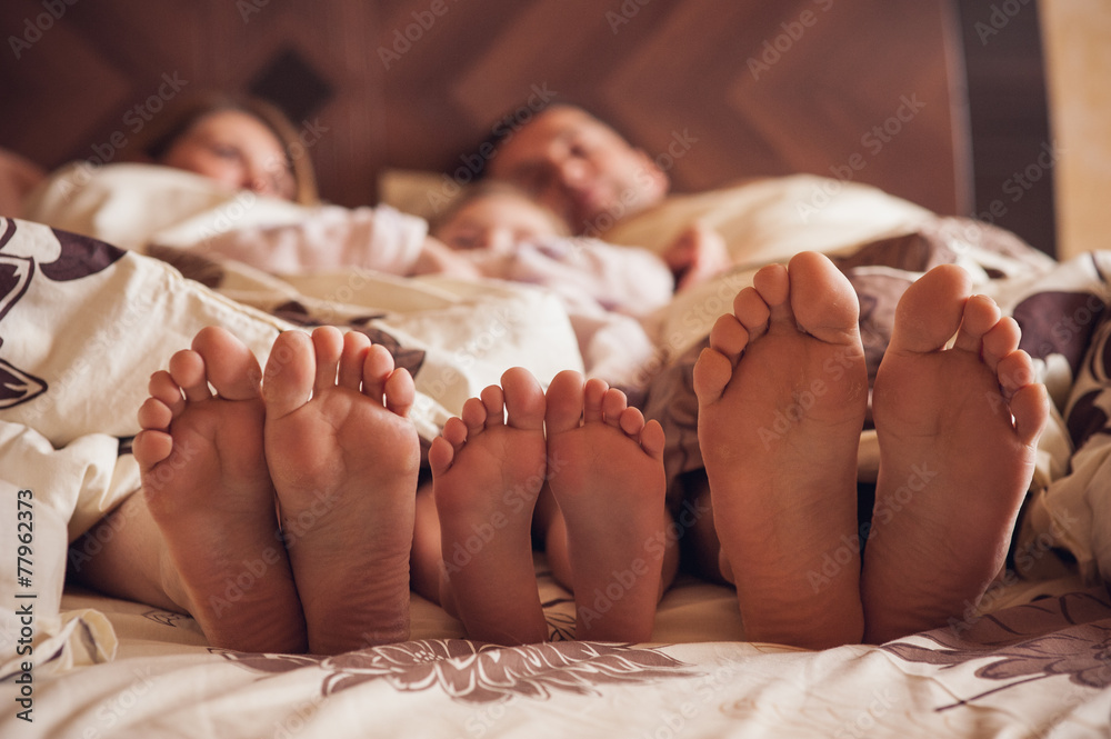 Family on the bed at home with their feet showing Stock Photo | Adobe Stock