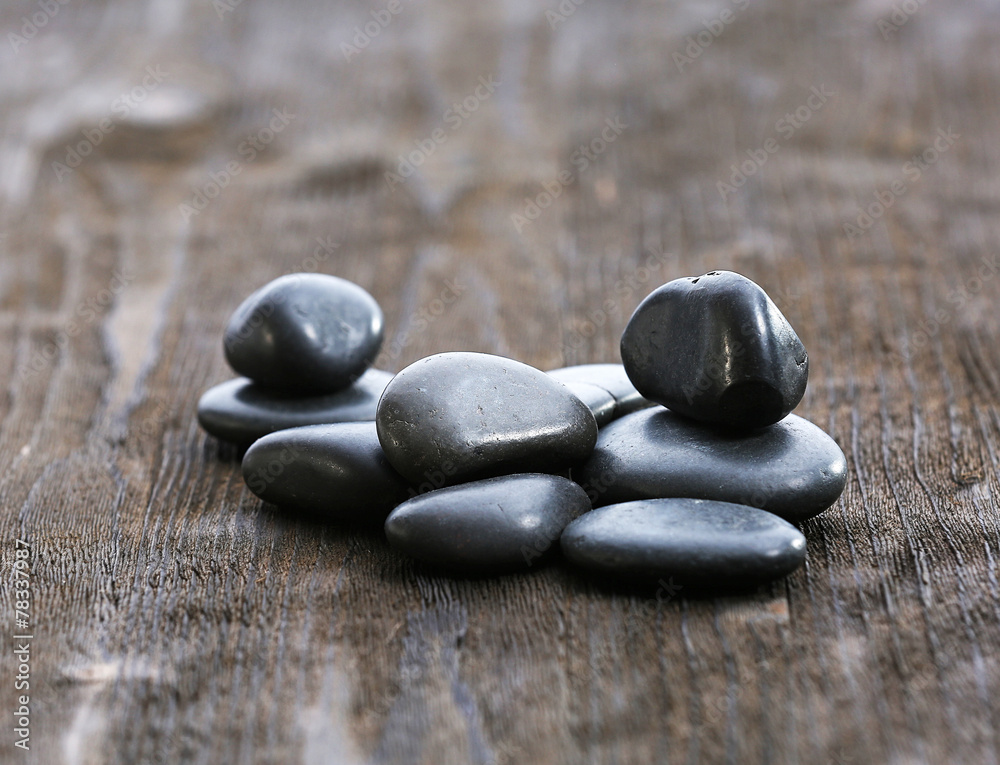 Stack of black sea pebbles on rustic wooden background Stock Photo ...