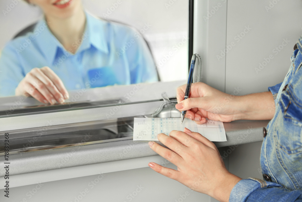 Teller window with working cashier and female hands with claim Stock ...
