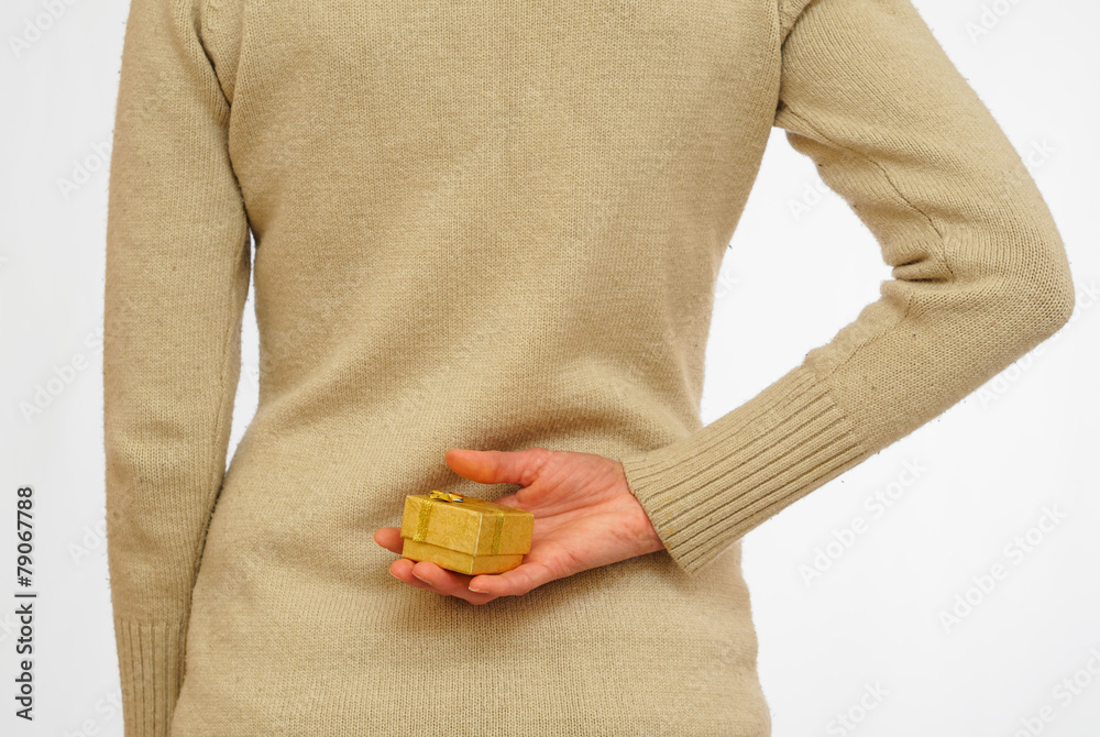 Female hiding present behind back Stock Photo | Adobe Stock