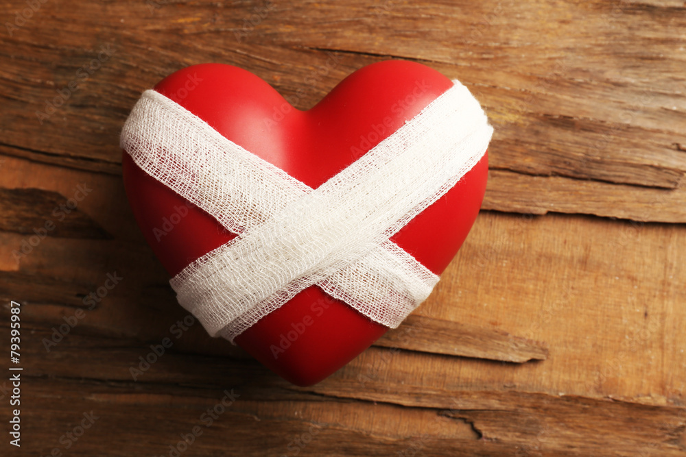 Tied heart with bandage on rustic wooden table background Stock Photo ...