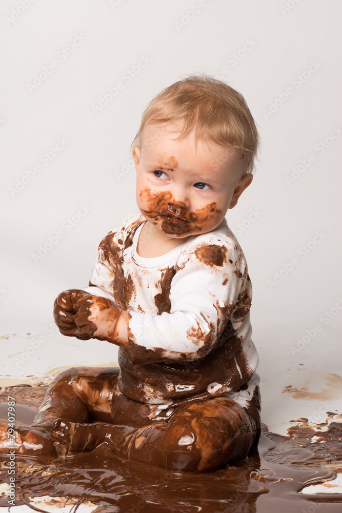 Kleines Baby mit Schokolade verschmiert Stock-Foto | Adobe Stock