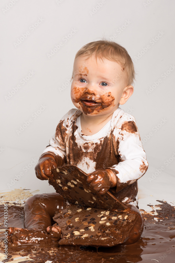 Kleines Baby mit Schokolade verschmiert Stock-Foto | Adobe Stock