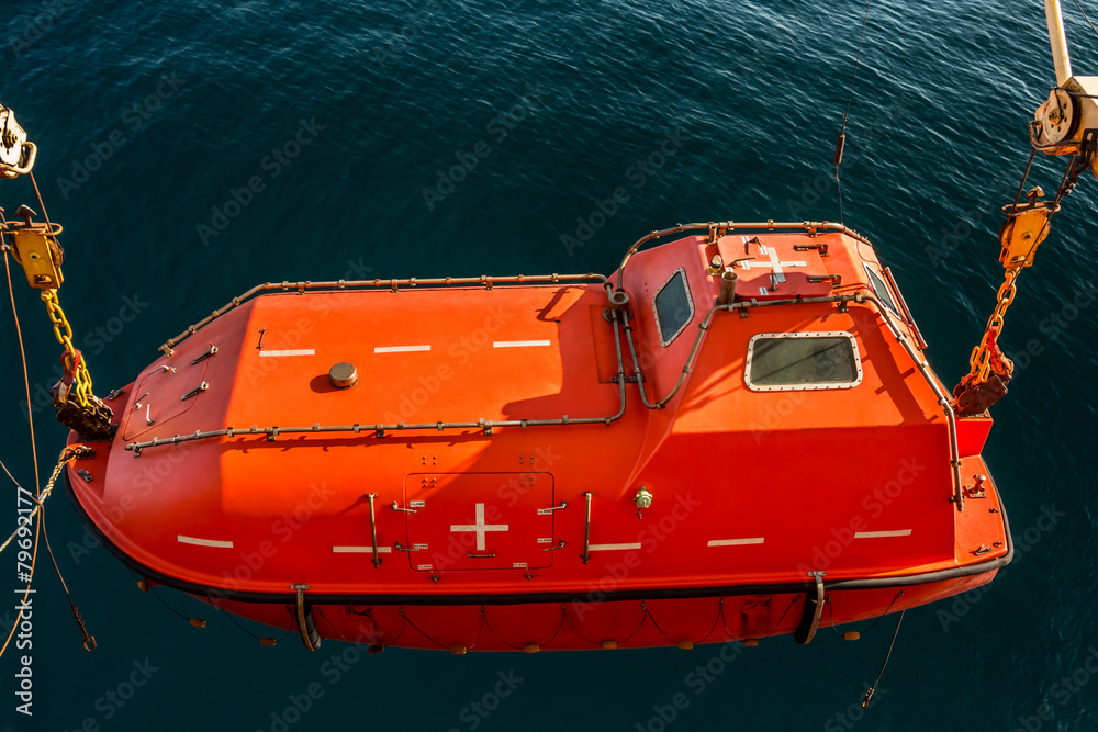 Lowered orange lifeboat with a sea background Stock Photo | Adobe Stock