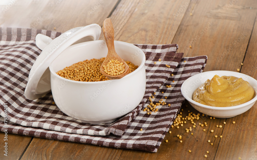 Mustard seeds and sauce on a wooden background Stock-Foto | Adobe Stock