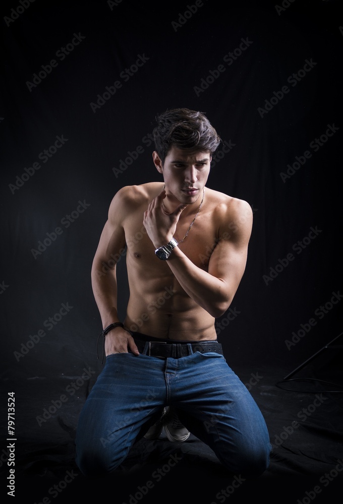 Handsome muscular shirtless young man kneeling down on the floor Stock ...