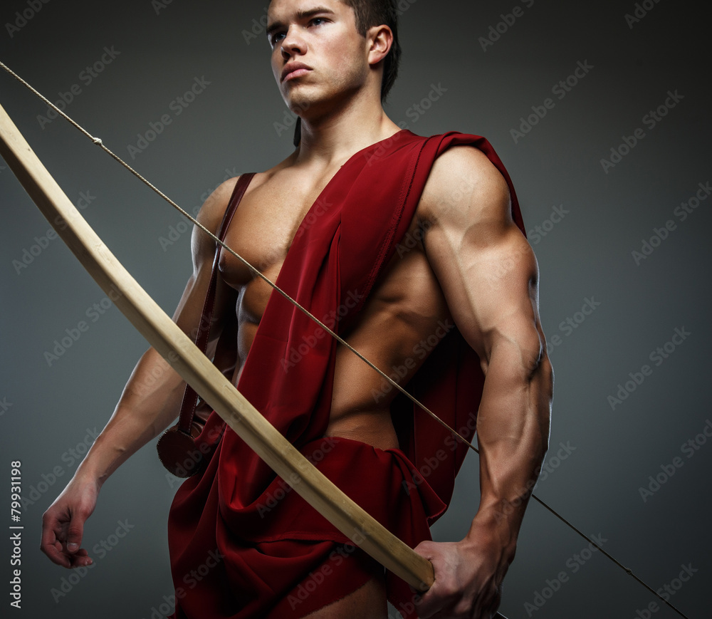Foto de Muscular guy with bow. do Stock | Adobe Stock
