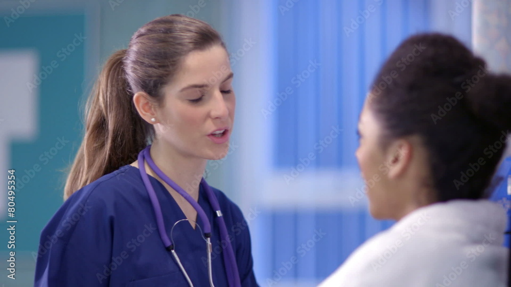 Caring nurse chats with a female patient on a hospital ward. Stock ...