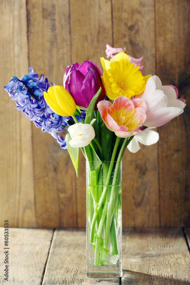 Beautiful spring flowers in glass vase on wooden background Stock Photo ...