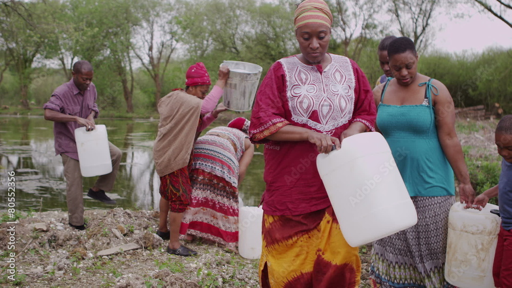 African villagers at river fill containers with as much water as they ...