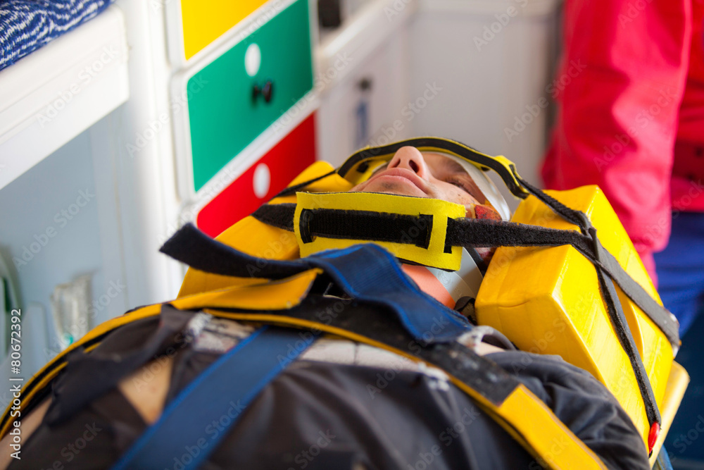 Injured man and an emergency worker inside an ambulance Stock Photo ...