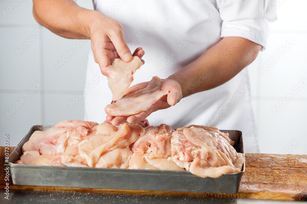 Butcher Holding Chicken Pieces At Counter Stock Photo | Adobe Stock