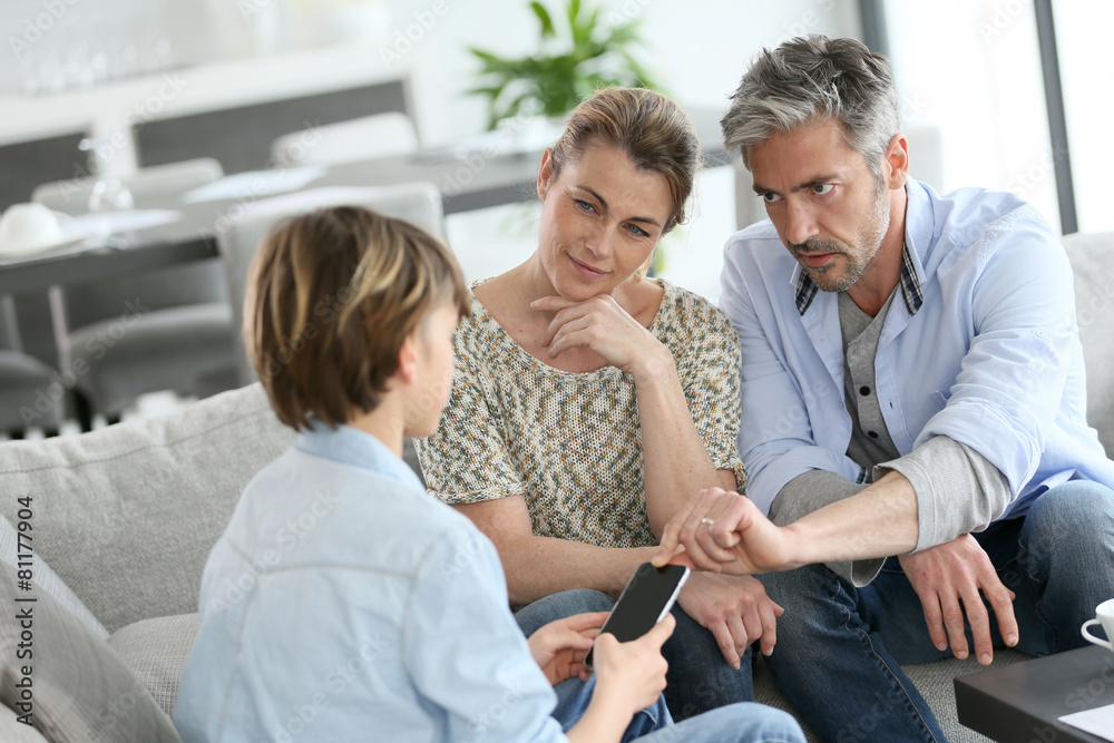 Parents giving smartphone to kid with warning Stock-Foto | Adobe Stock