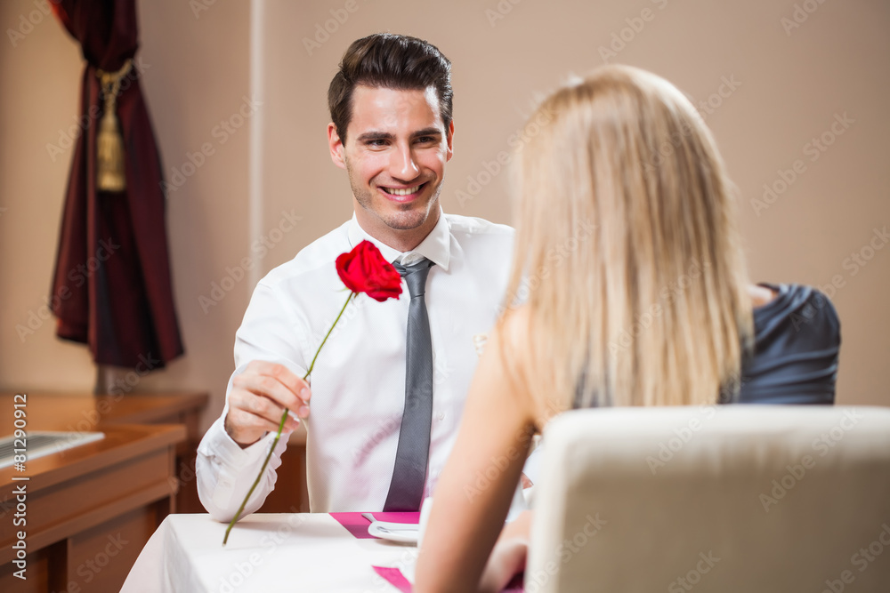 Man is giving rose to his girlfriend at the restaurant foto de Stock ...