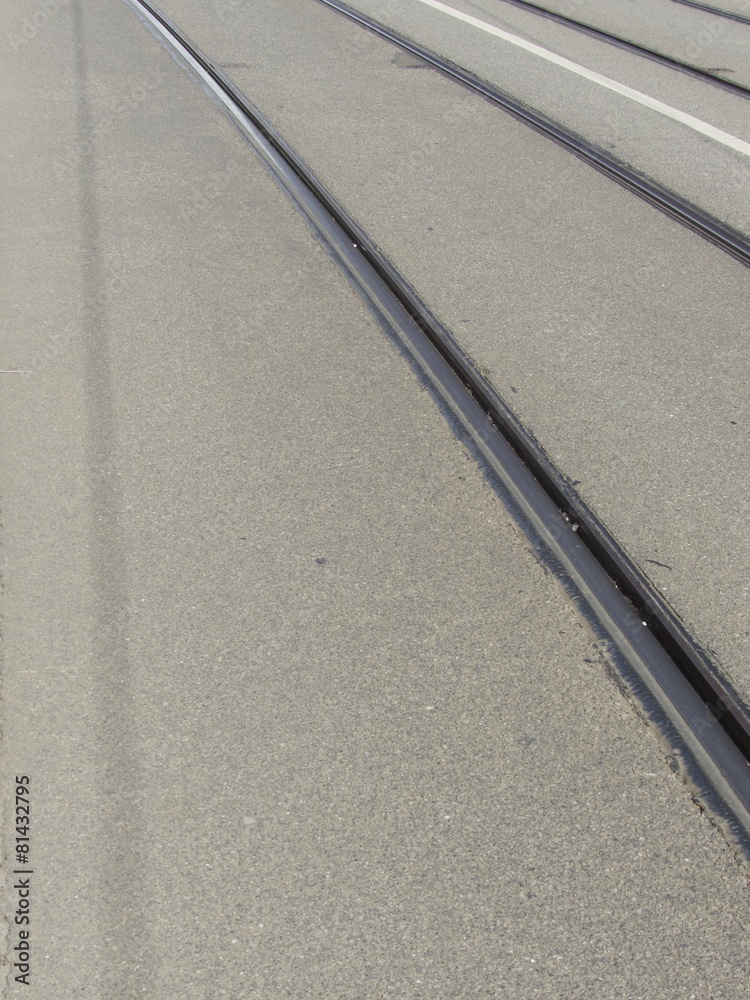Straßenbahnschienen in grauem Asphalt im Sommer bei Sonnenschein in der ...