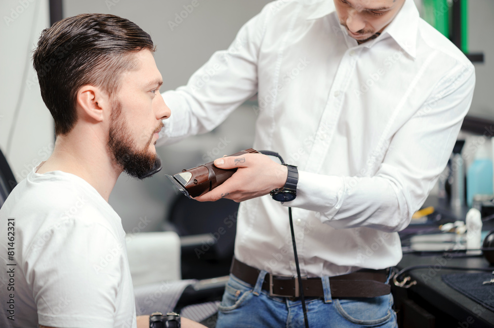 Man shaves his beard with a hair clipper Stock-Foto | Adobe Stock Man shaves his beard with a hair clipper Stock-Foto | Adobe Stock