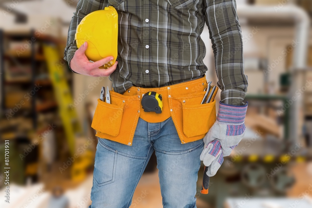manual worker wearing tool belt while holding gloves and helmet Stock ...
