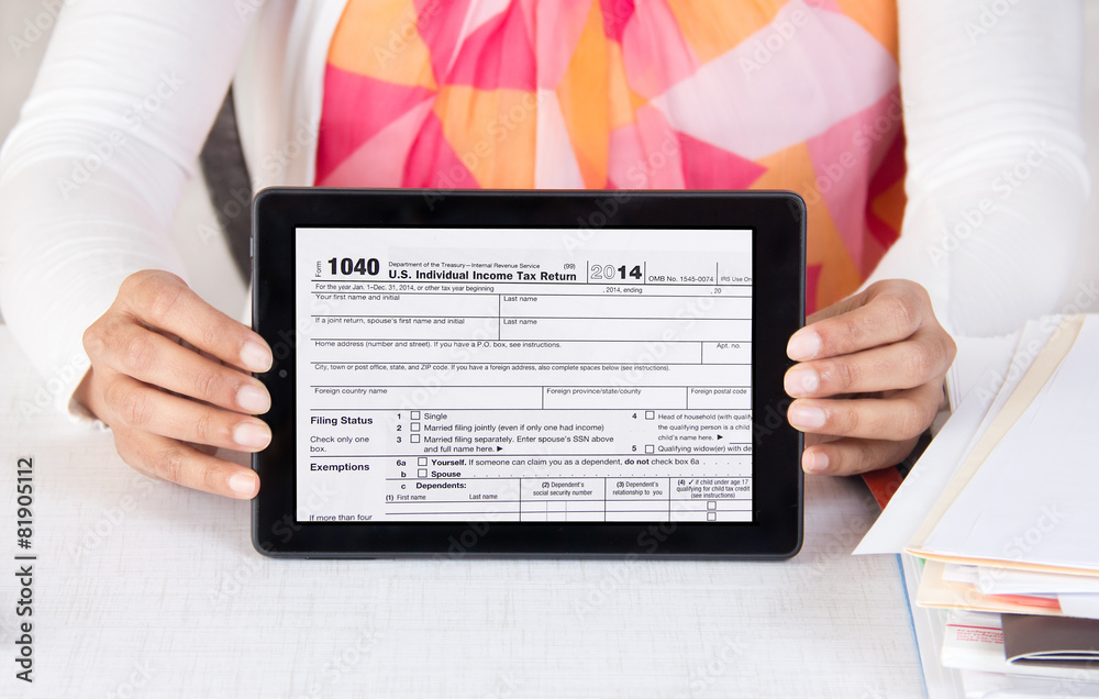 Business official showing income tax form 1040 in a tablet compu Stock ...