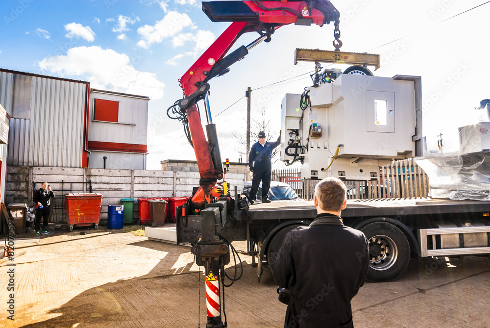 Crane truck lifting heavy CNC machine with hydraulic arm Stock Photo ...