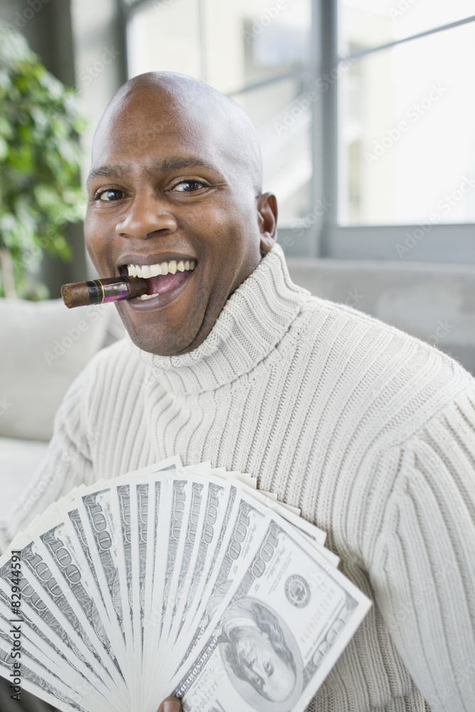 African man smoking cigar and holding 100 dollar bills Stock Photo ...