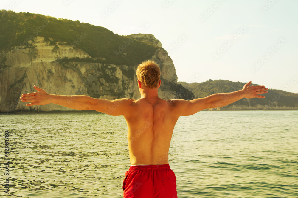 Mann mit Muskeln am Meer springt ins Wasser Stock-Foto | Adobe Stock