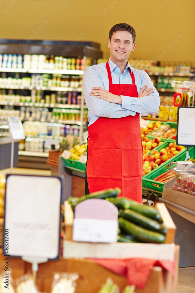 Salesman with arms crossed in supermarket Stock Photo | Adobe Stock