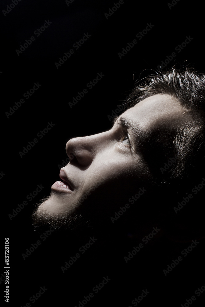 Man side profile portrait looking up lighted on a half face Stock-Foto | Adobe Stock
