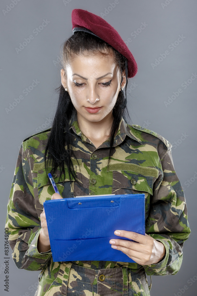 Military female writing in notebook isolated on gray background Stock ...