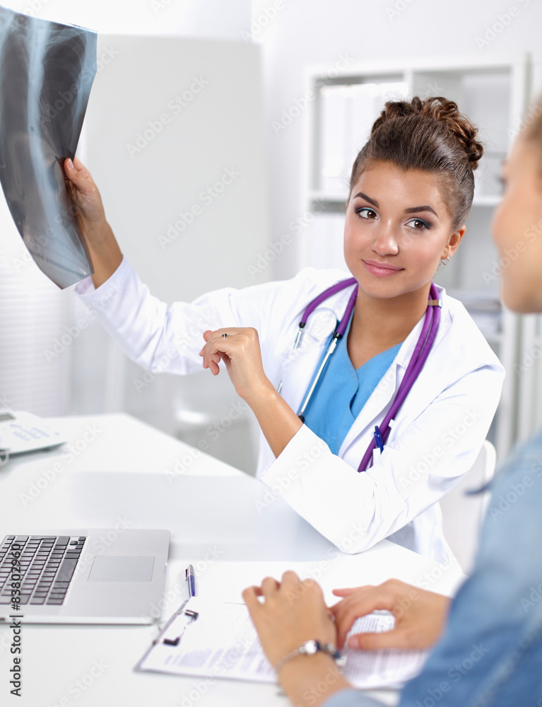 Young female doctor studying x-ray image sitting on the desk Stock ...