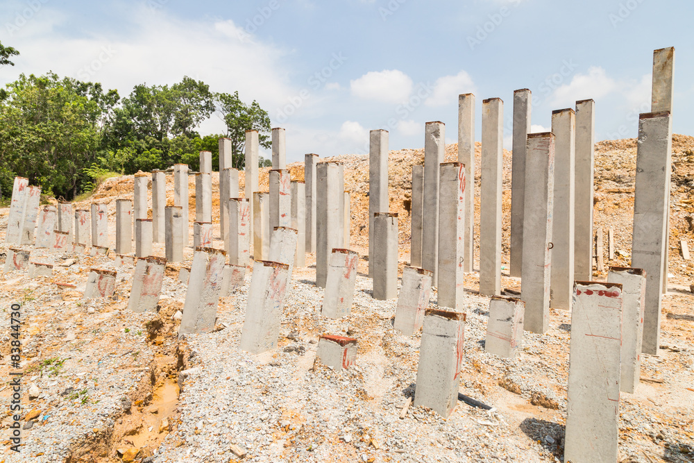 Piling concrete columns pounded into ground at construction site Stock ...