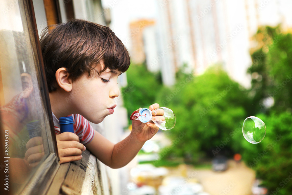 preteen handsome boy with soap bubbles lood out of the window Stock ...