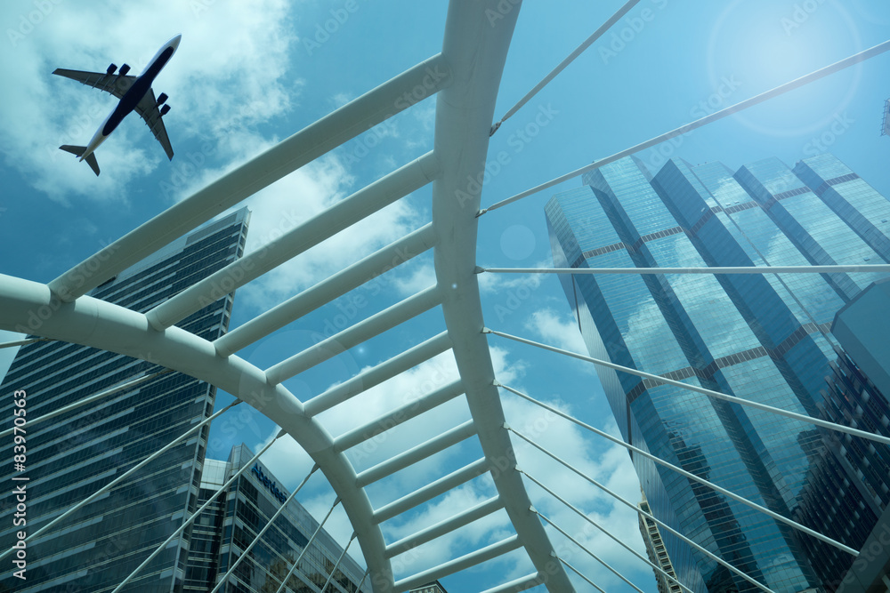Airplane in the sky with modern buildings Stock Photo | Adobe Stock