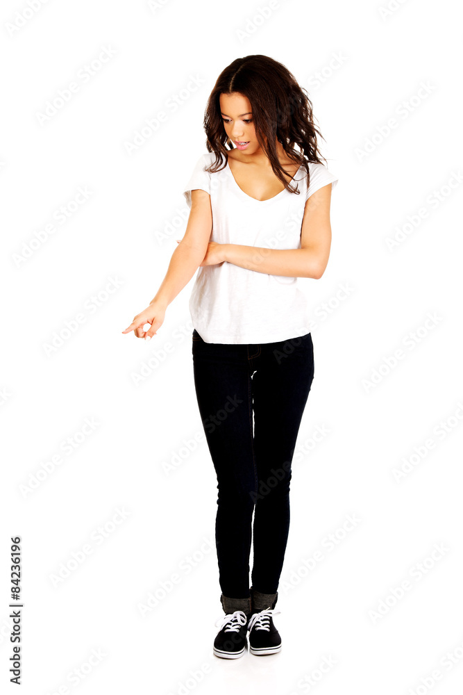 Young woman pointing down. Stock Photo | Adobe Stock