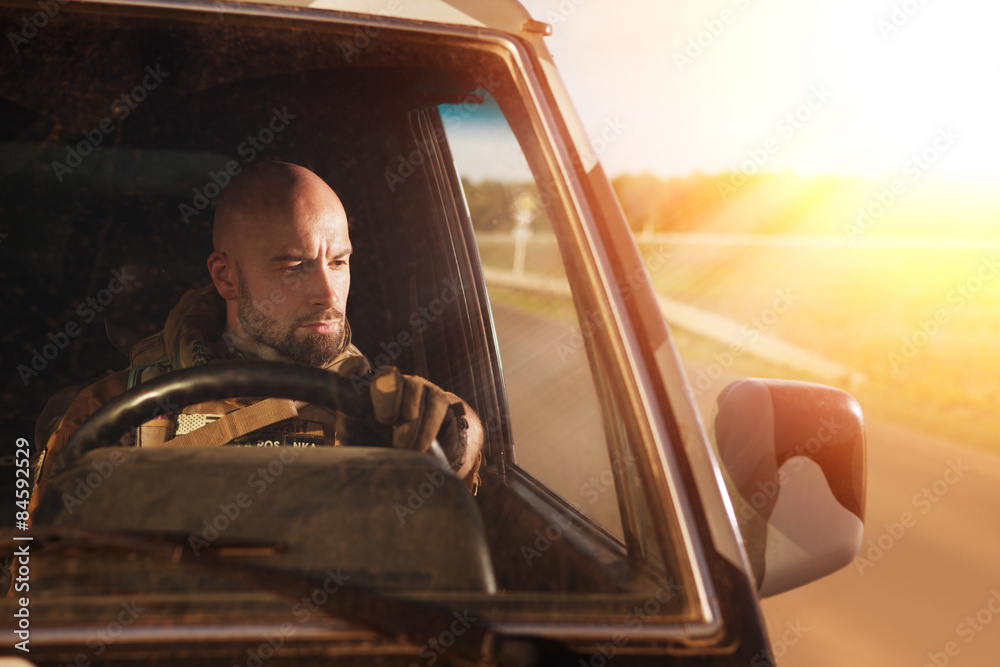 Bald soldier in uniform is driving military vehicle. Stock Photo ...