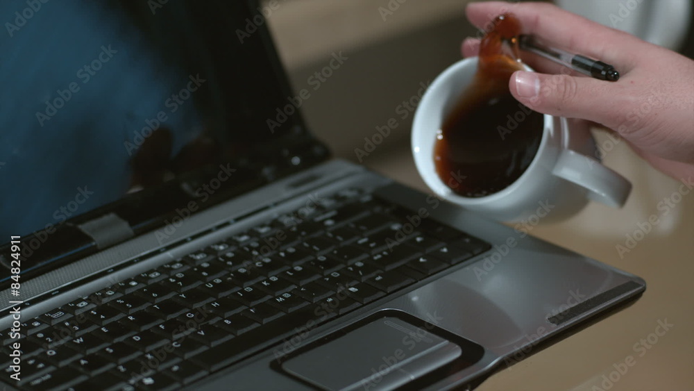 Spilling coffee on laptop computer slow motion Stock Video | Adobe Stock