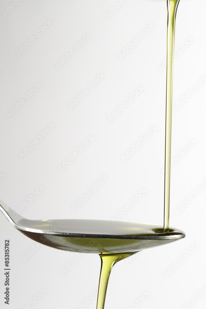 Trickle of extra-virgin olive oil on a spoon Stock Photo | Adobe Stock