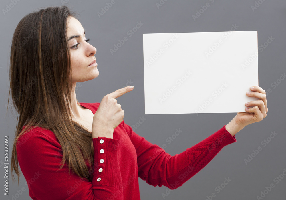 proud young lady pointing at a claim on blank board that she holds from ...