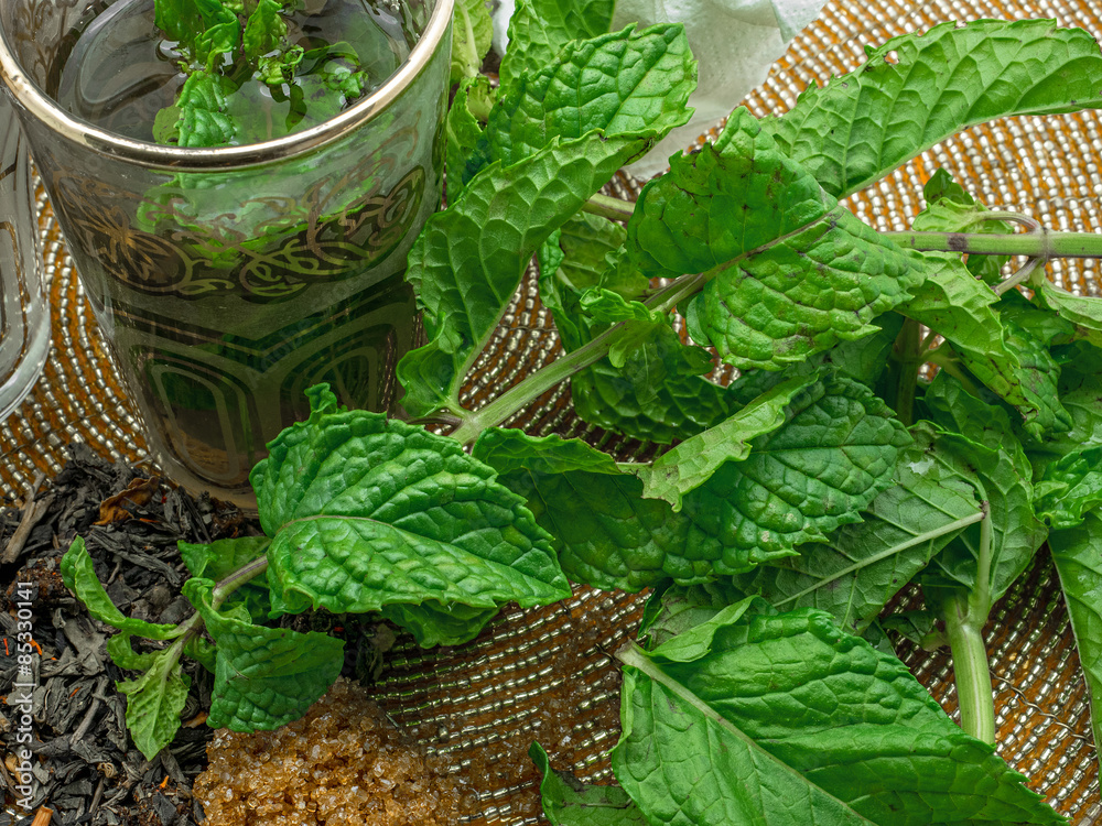 Black tea in a crystal glass, mint leaves, dried tea, brown suga Stock Photo | Adobe Stock