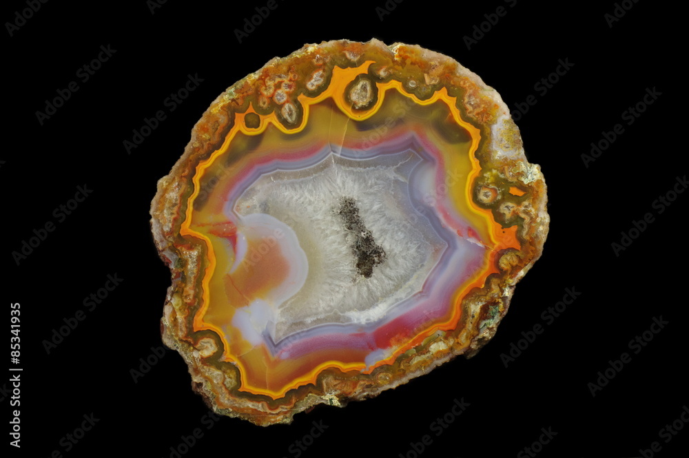 A cross section of agate stone with geode on a black background. Origin ...