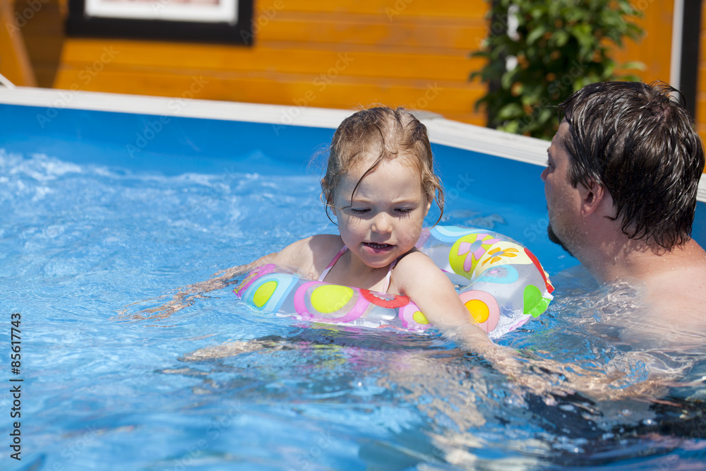Child girl in bikini bathing in the pool with his father Stock Photo ...