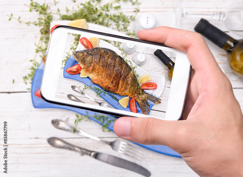 Hands taking photo fish with smartphone. Stock Photo | Adobe Stock
