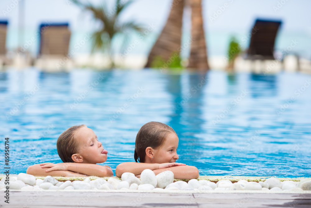 Adorable little girls playing in outdoor swimming pool Stock Photo ...