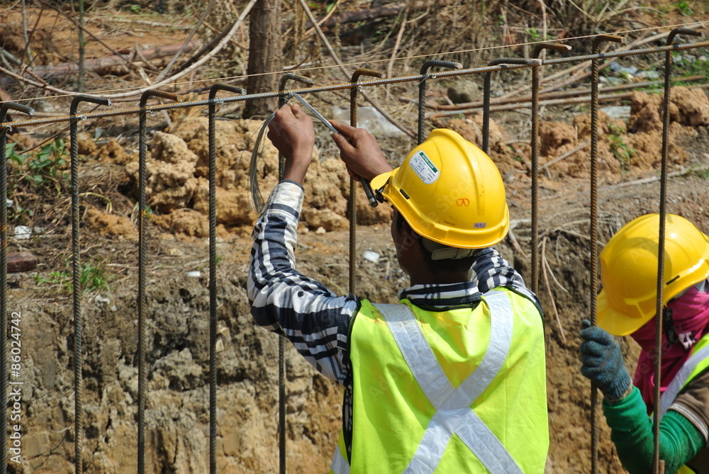 Construction workers fabricate retaining wall reinforcement bar at the ...