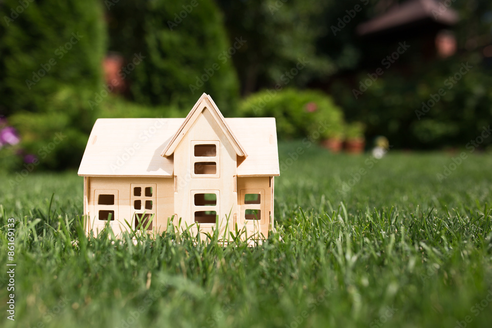 Wooden model of house on grass, summer outdoor, new home concep Stock ...