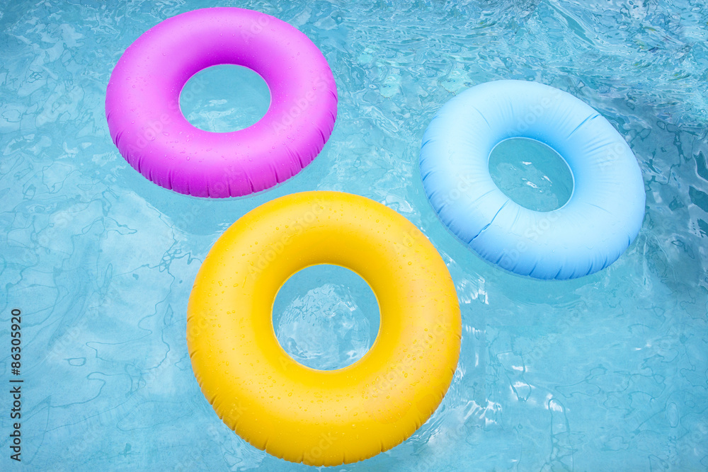 Group of colorful inflatable tubes floating in a swimming pool Stock ...