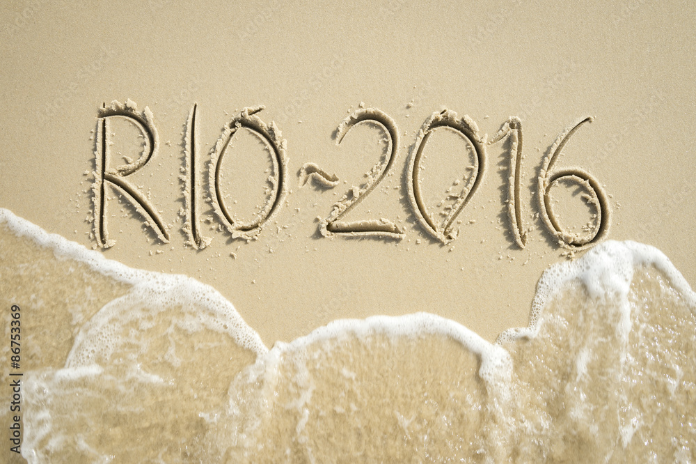Simple Rio 2016 message handwritten in clean numbers on smooth sand ...
