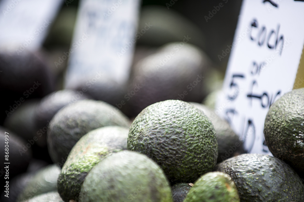 Bins of ripe avocados at a farmers market. Black and white hand written ...