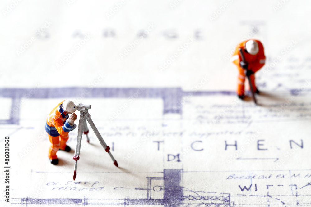 Miniature construction workers building plans. Miniature scale model ...